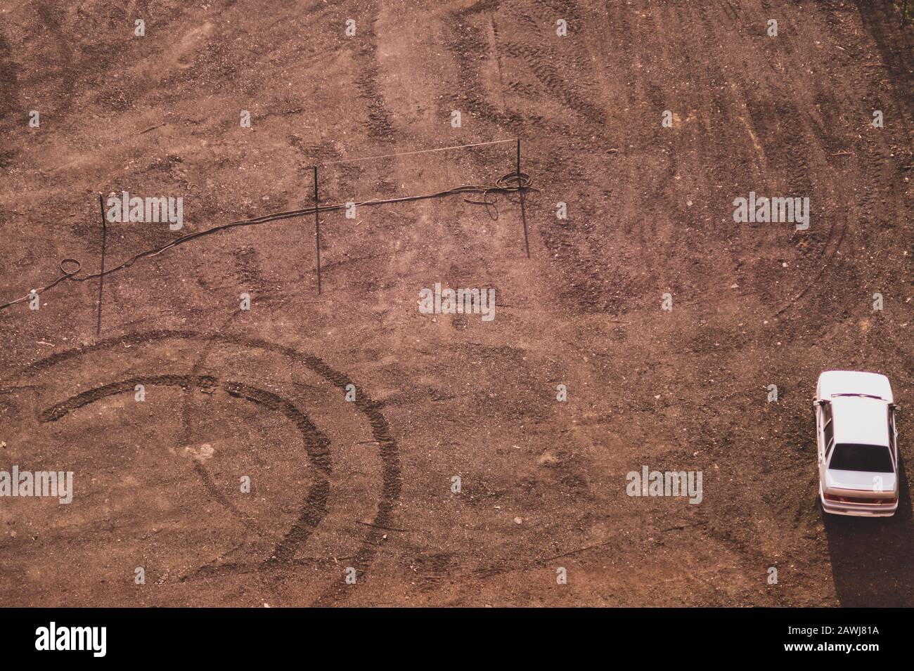 Car stands on the sand aerial view. ground with tracks and footprints ...