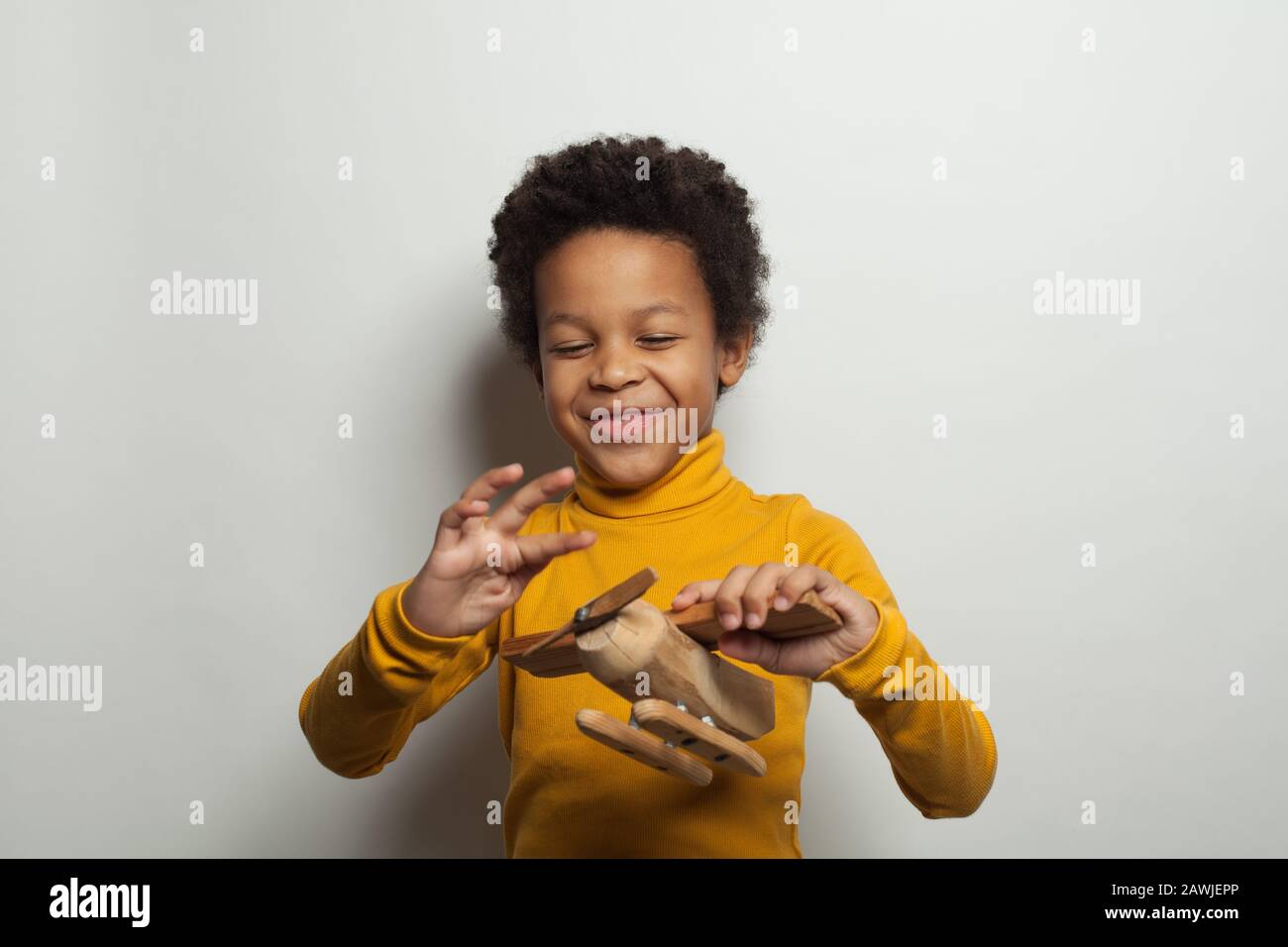 Happy black kid boy playing plane model on white background Stock Photo ...