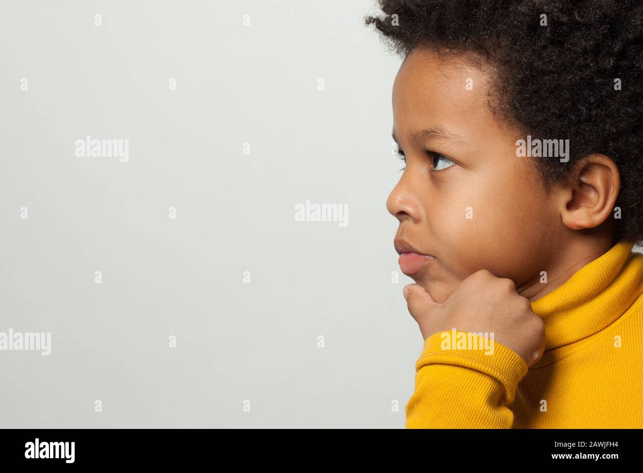 Smart black child boy thinking on white background Stock Photo - Alamy