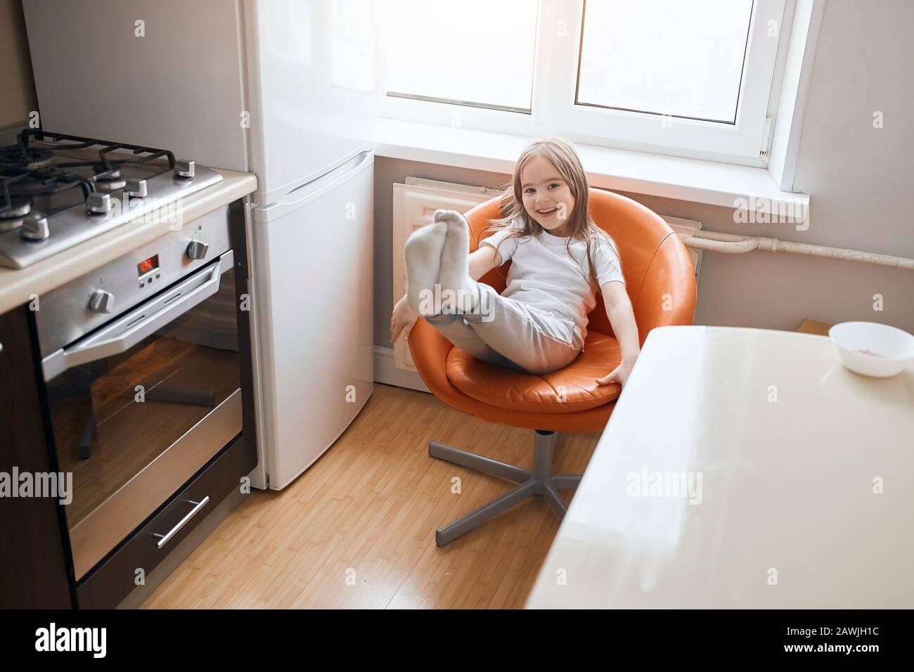 cheerful happy beautiful cute girl sitting on the chair with raised ...