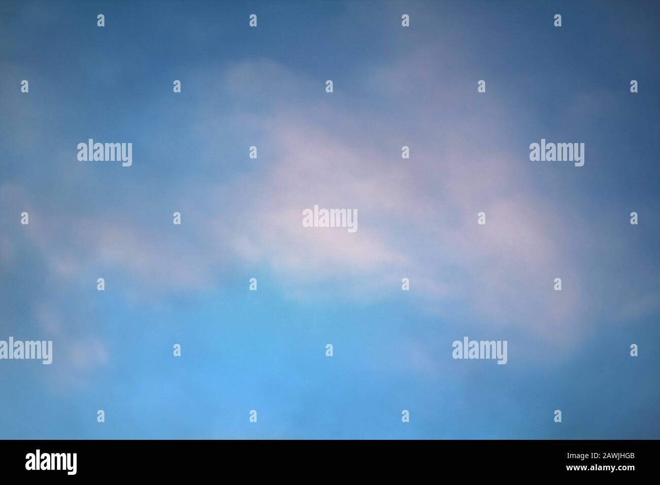 Dramatic blue sky with clouds backlit by the sun at dusk. Background ...