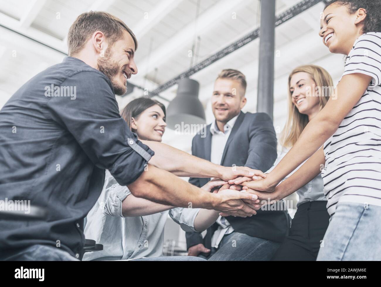 Close up view of young business people putting their hands together. Stack of hands. Unity and ...