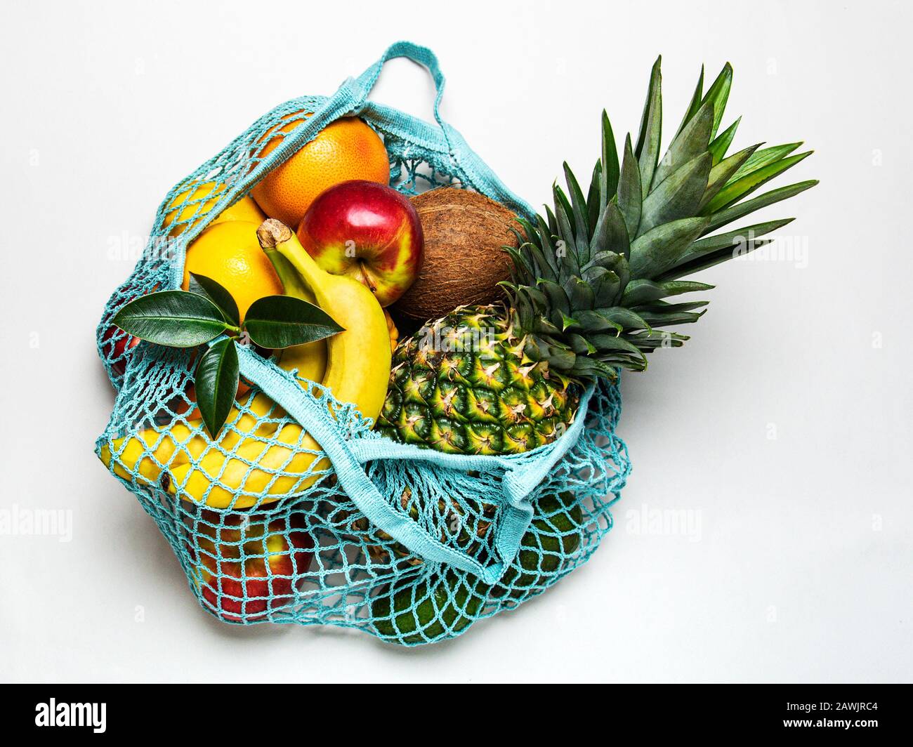 Mesh shopping bag with organic fruits on white background. Flat lay ...