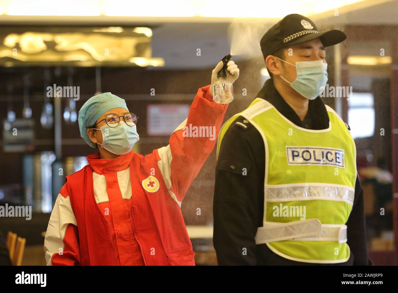 A Chinese medical worker disinfects a police officer for prevention of ...