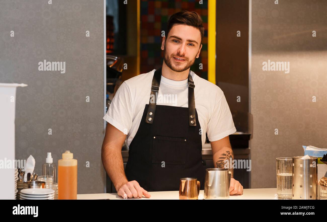 Barista Standing At Counter Smiling To Camera In Coffee Shop Stock ...