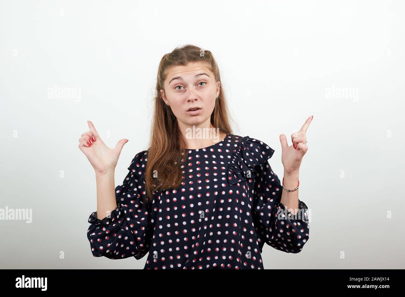girl in a black dress surprised shocked woman raises index fingers to ...