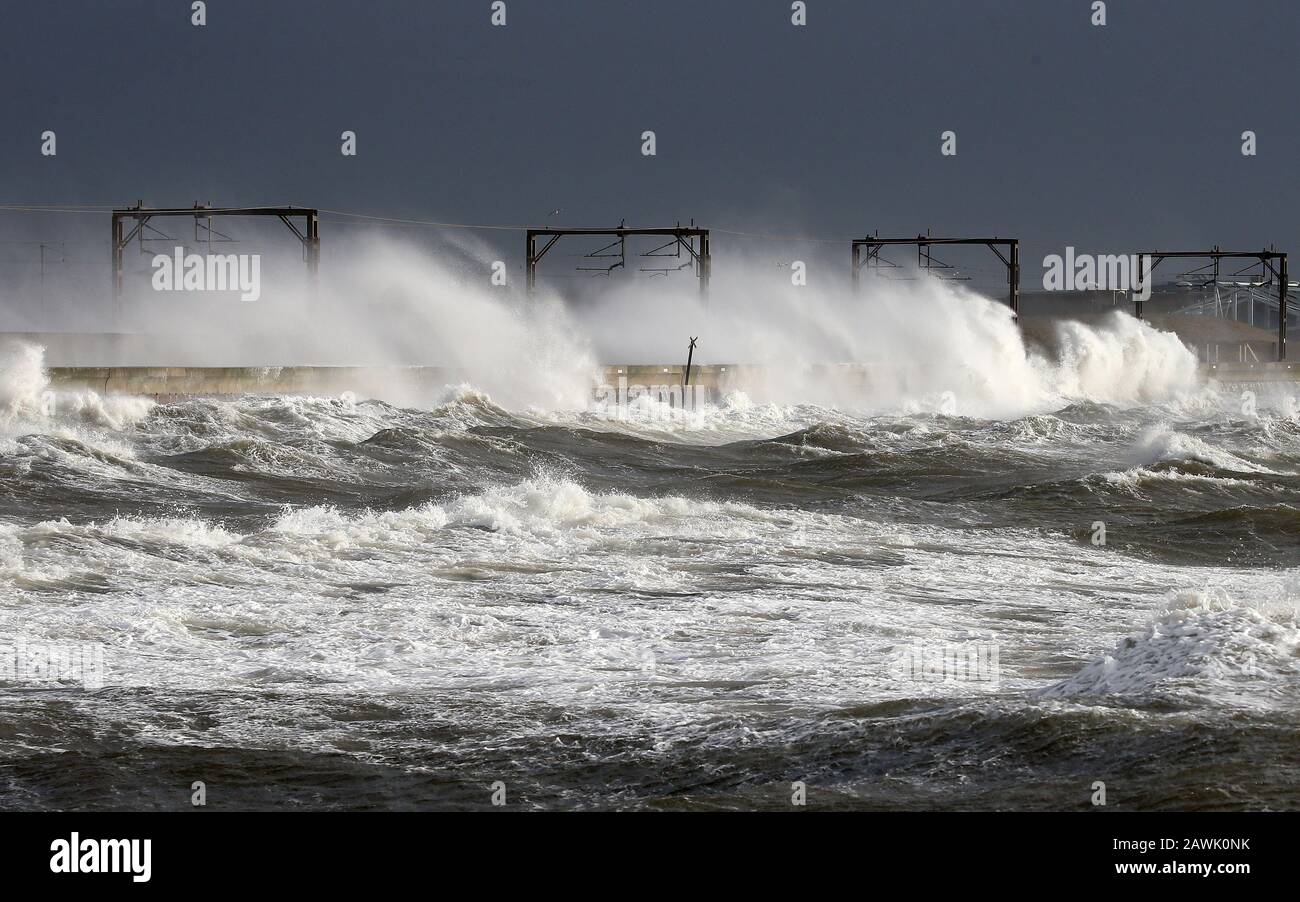 Waves batter the train line at Saltcoats on the Ayrshire coast Stock ...