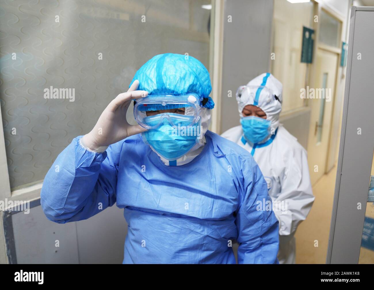 A Chinese doctor and a nurse wearing protective clothing visit and ...