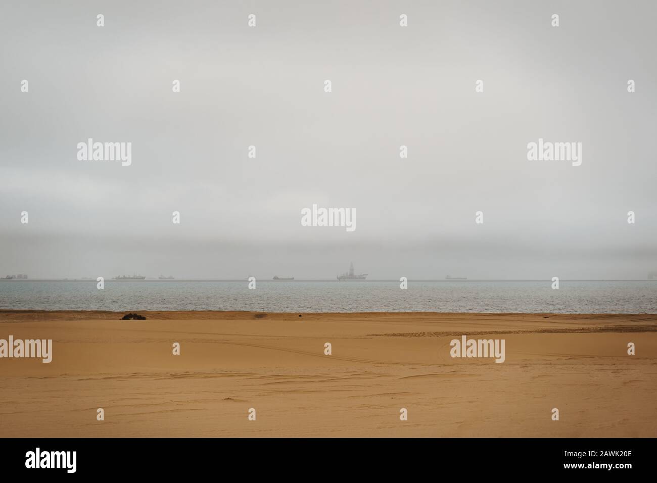shore coast with oil tankers on the sea in bad weather with stormy ...