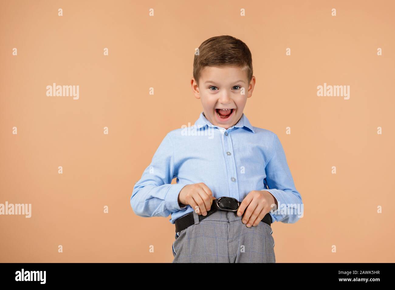 satisfied little child boy looking to camera on beige background. Human ...