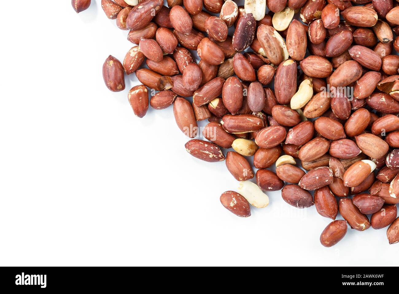 peeled peanuts sprinkled on a white background. nutritious vegetable ...