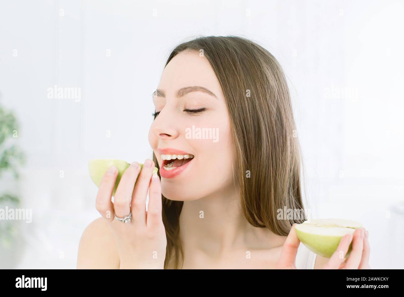 Close-up face of beautiful woman with clean fresh healthy skin, eating ...