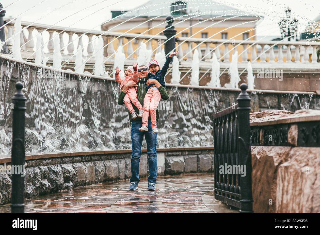 Moscow, Russia - JULY 7, 2017. A happy father in sunglasses holds two ...