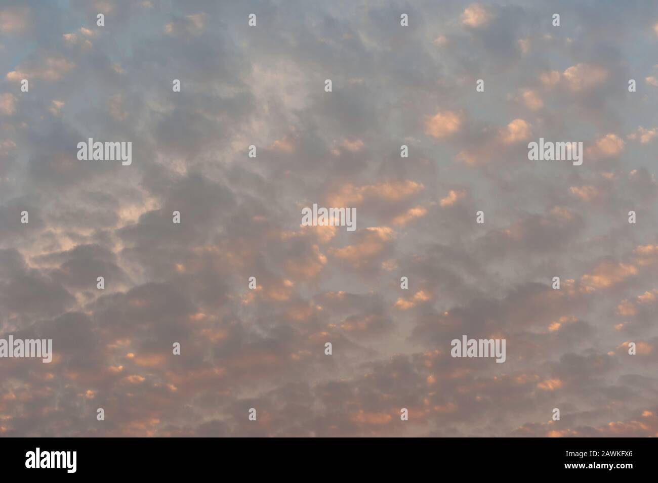 Cumulus sunset clouds with sun setting down Stock Photo - Alamy