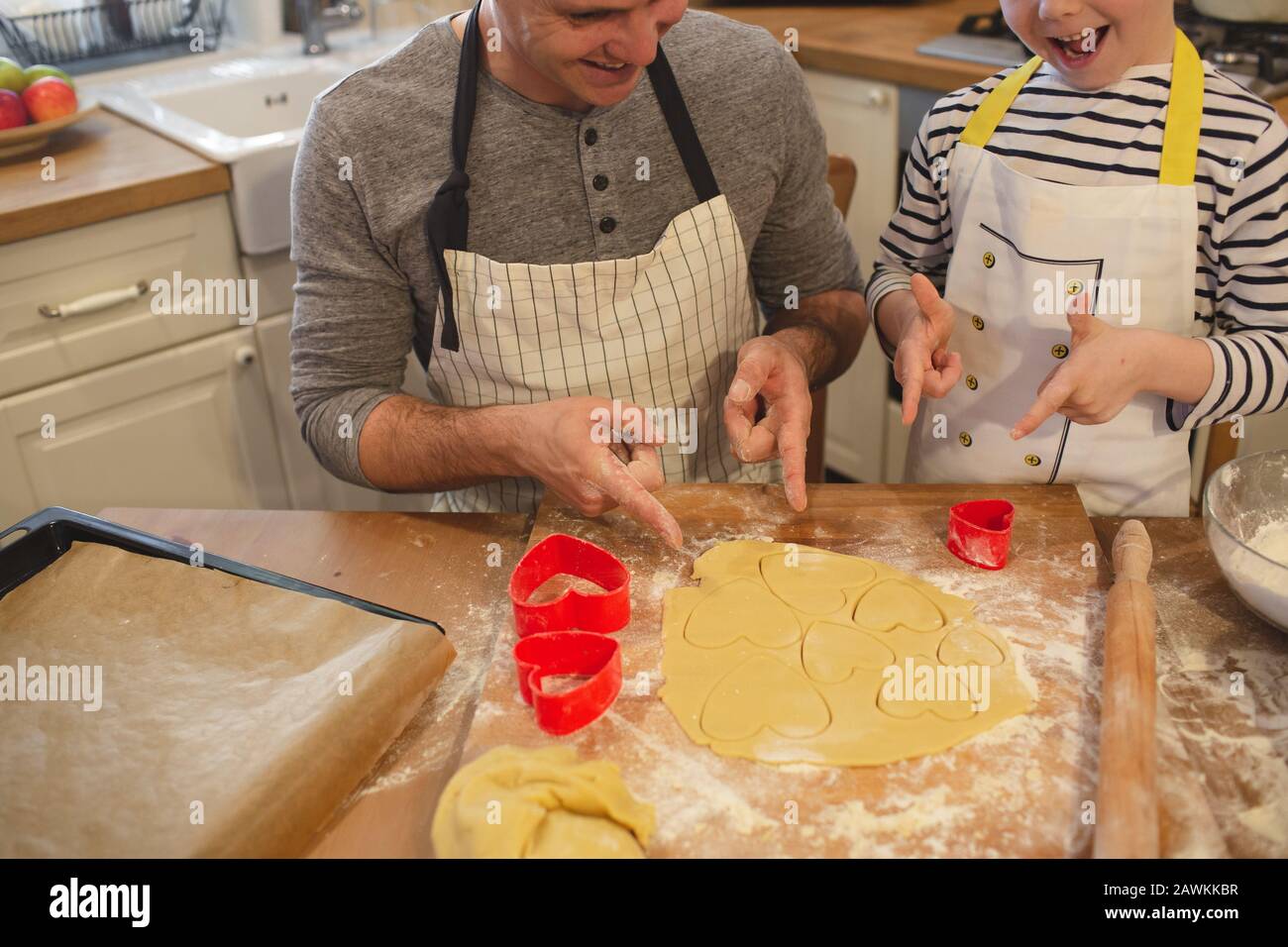 Dad and son in chef's hats are cooking Stock Photo - Alamy