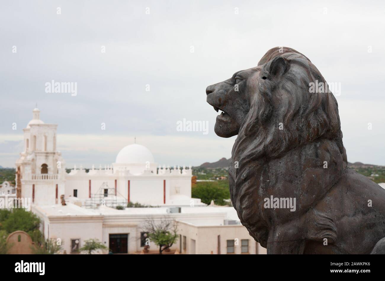 A bronze Lion and the Mission San Xavier del Bac in a Cloudy Day ...