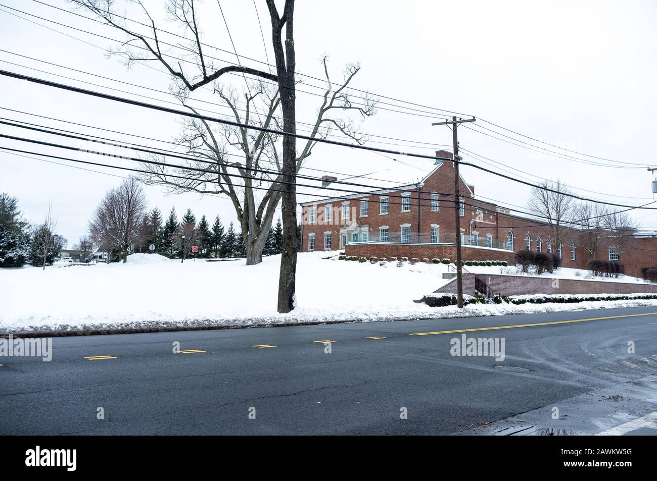 classic red brick building in the snow in small American town in early ...