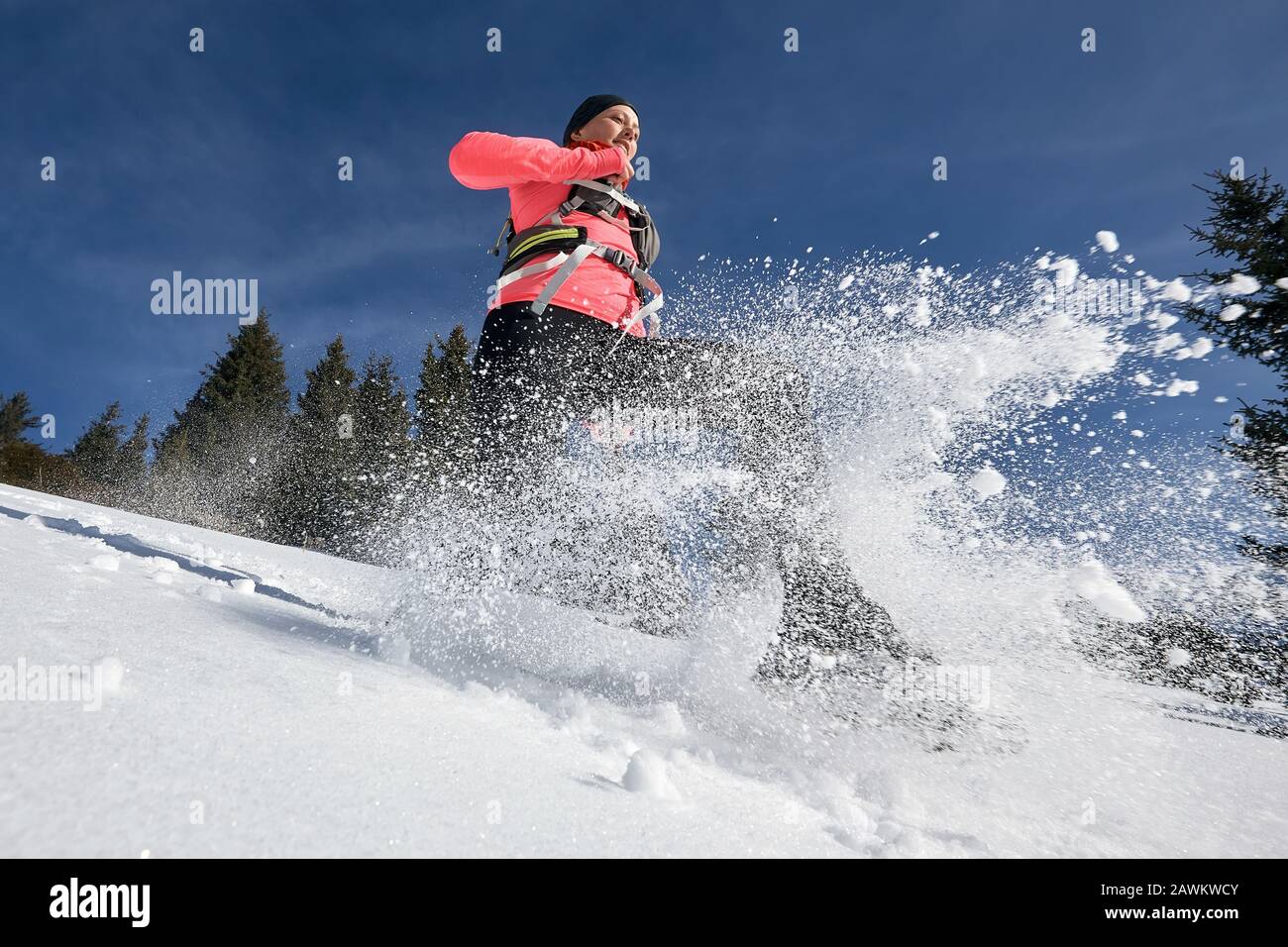 Trail runner woman running in winter mountains on snow. Dynamic running ...