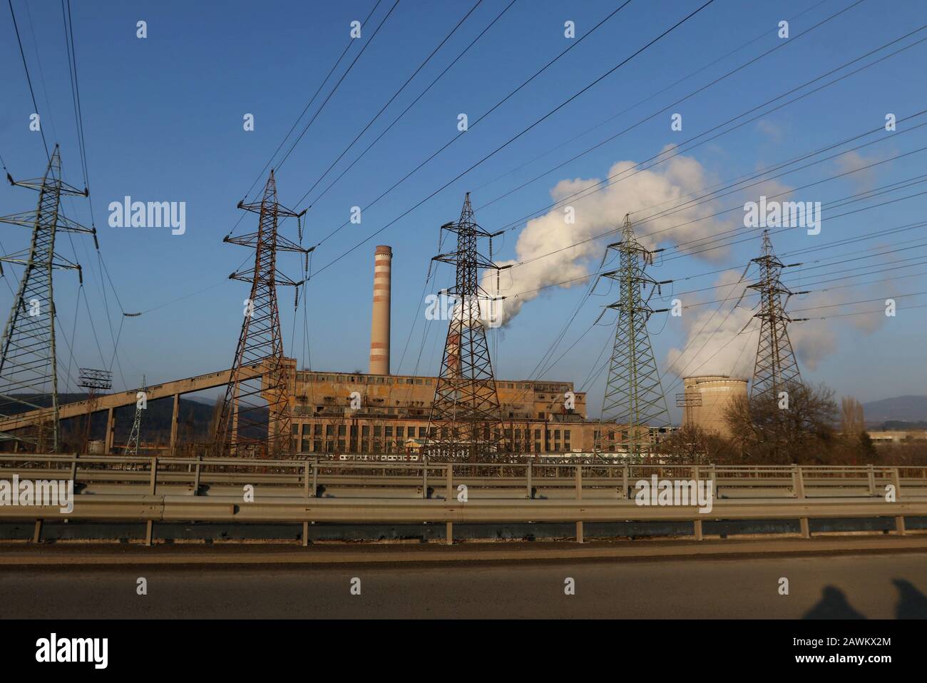 Smoking chimney of thermal power station plant and electric pole. High ...