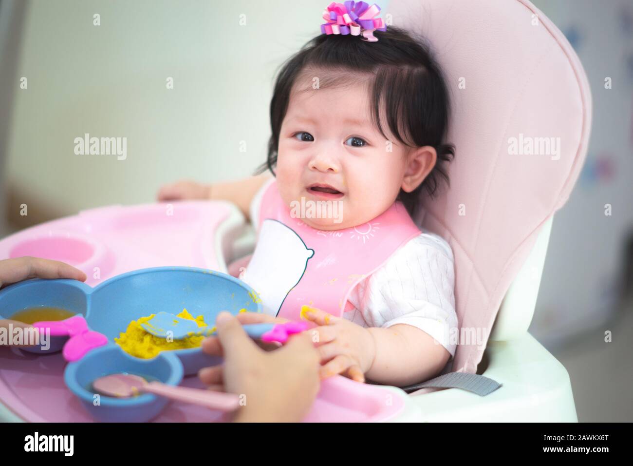 Unpleasant Asian Thai Baby Girl with First Time Meal Stock Photo - Alamy