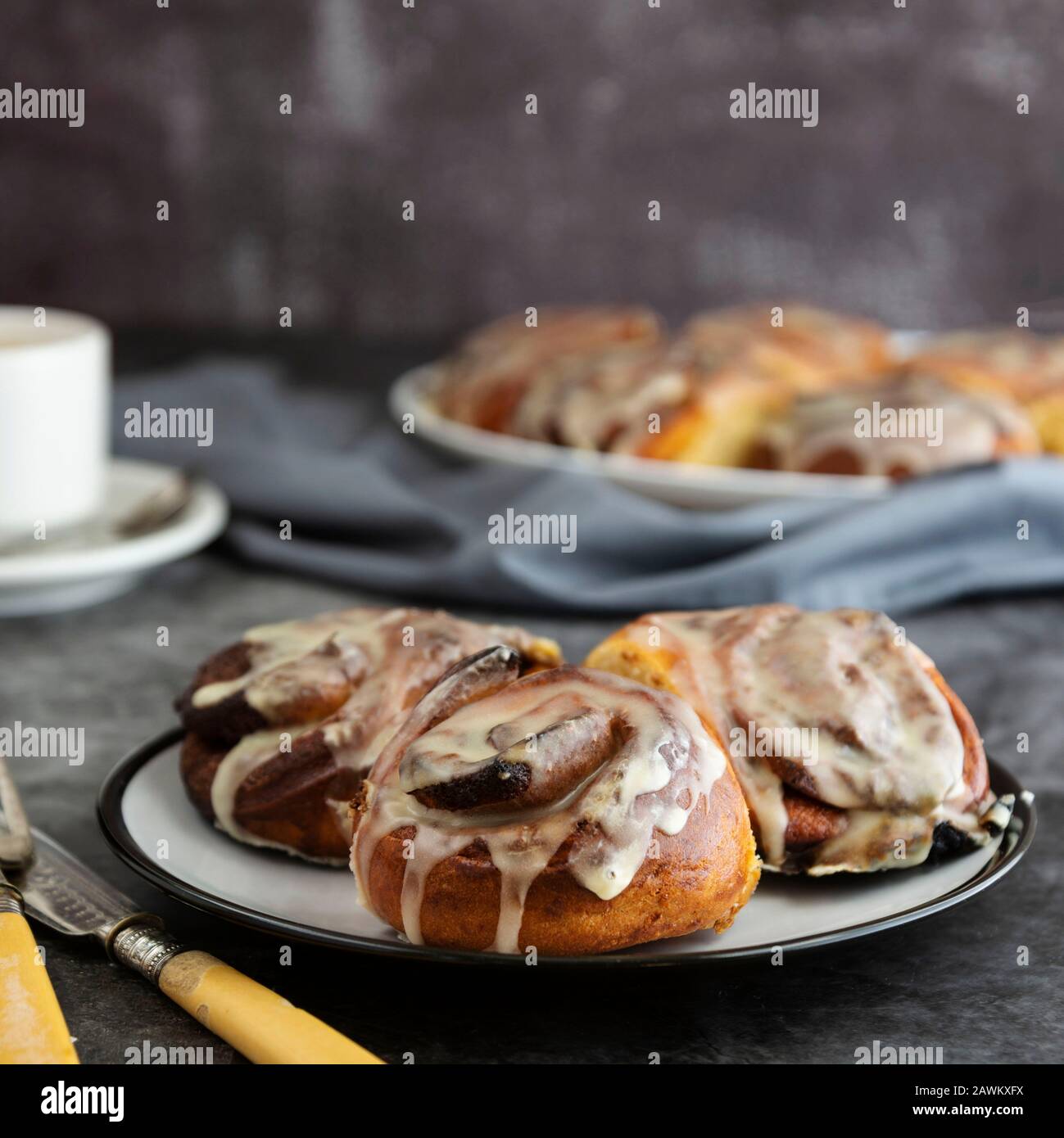 Cinnamon danish bun or cinnabons on dark background with coffee cup ...