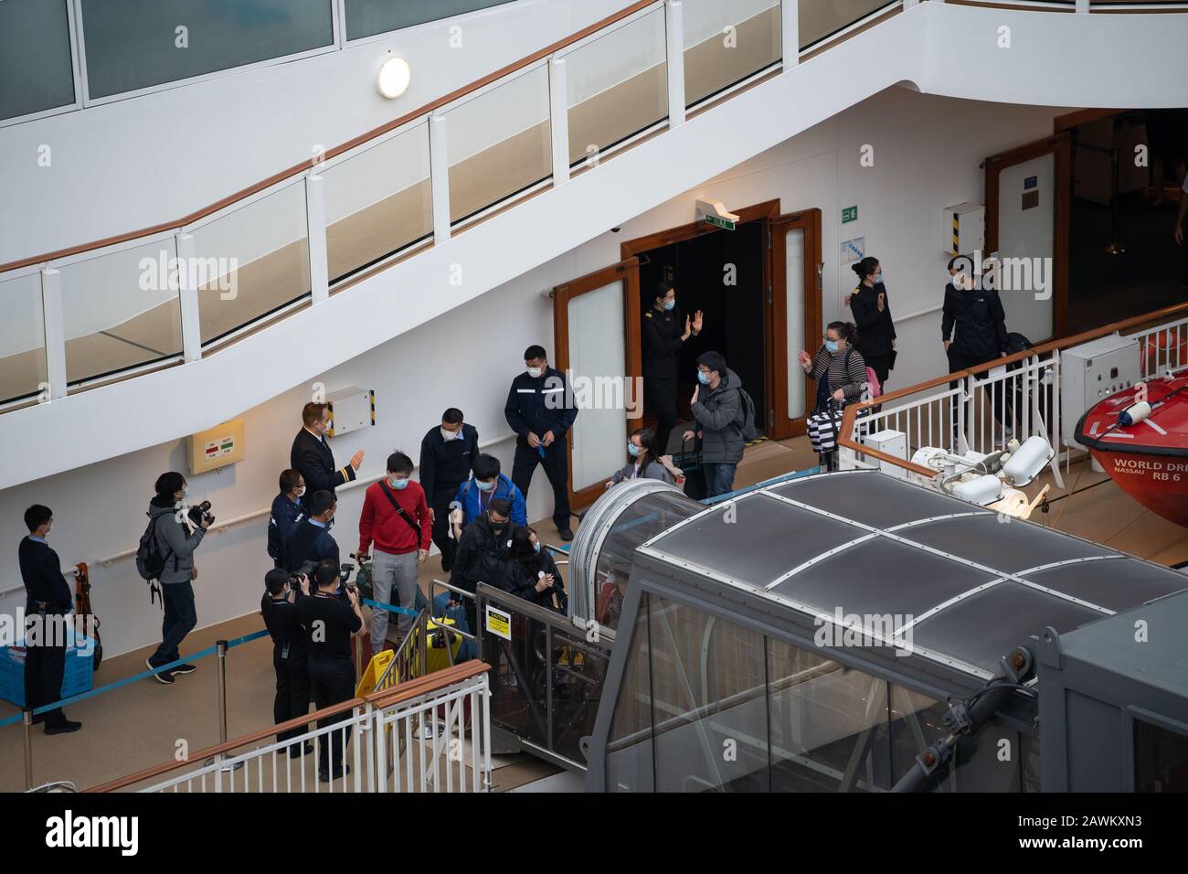 Passengers queue up to finally disembark from the World Dream cruise ...
