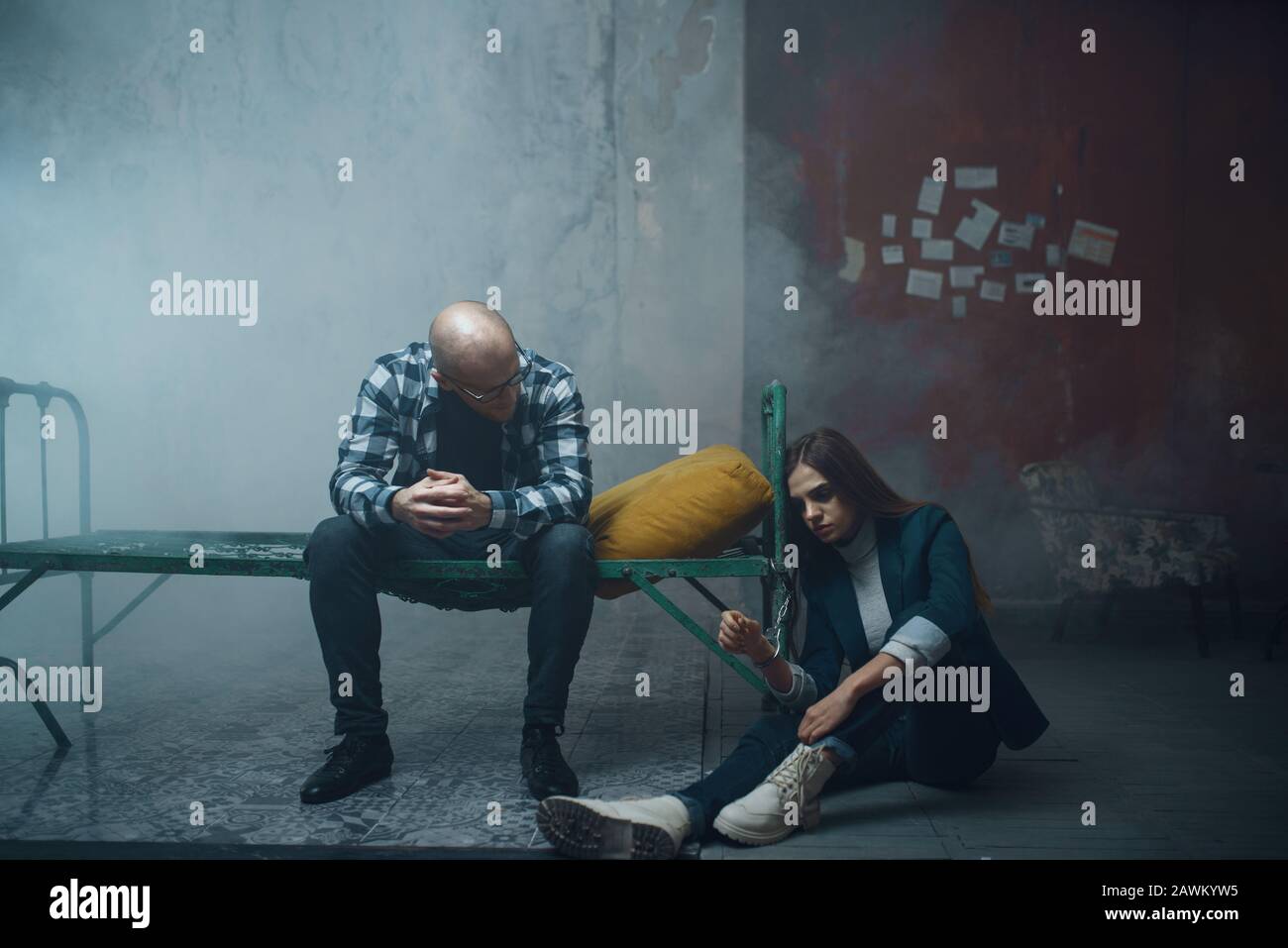 Maniac kidnapper and victim handcuffed to the bed Stock Photo - Alamy