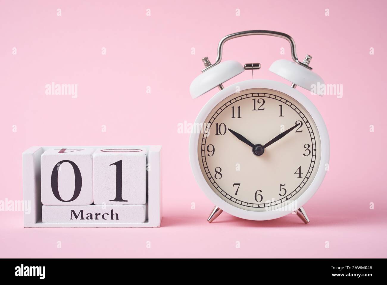 White retro alarm clock with bells and wooden calendar blocks with date ...