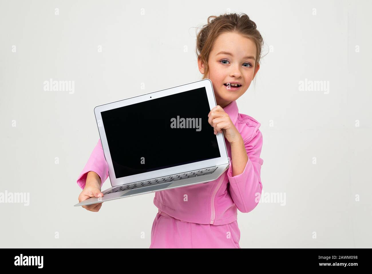 Closeup portrait of an attractive young girl in a pink suit showing a ...