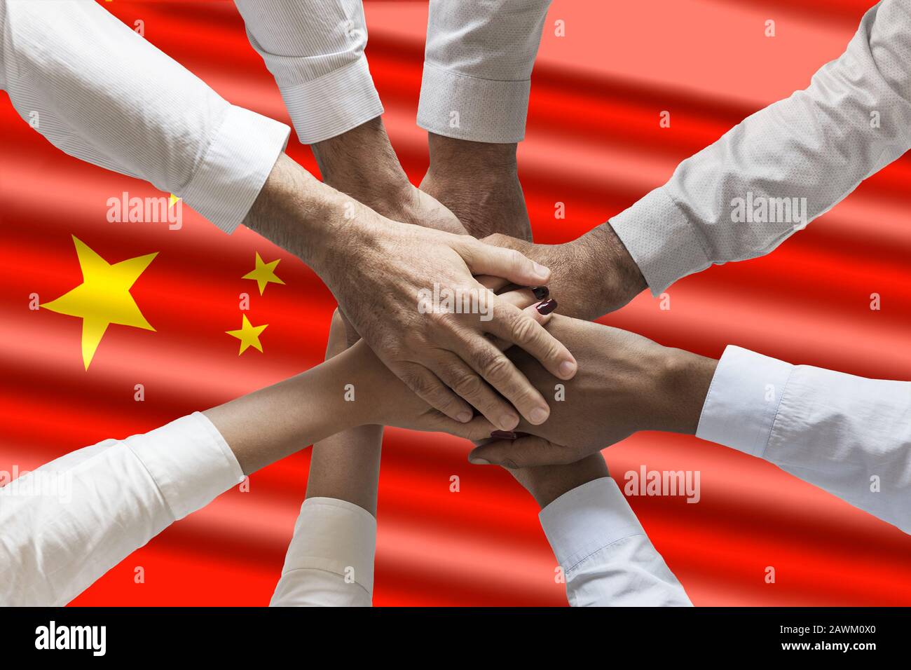 stack of hands showing unity and teamwork over waving chinese flag ...