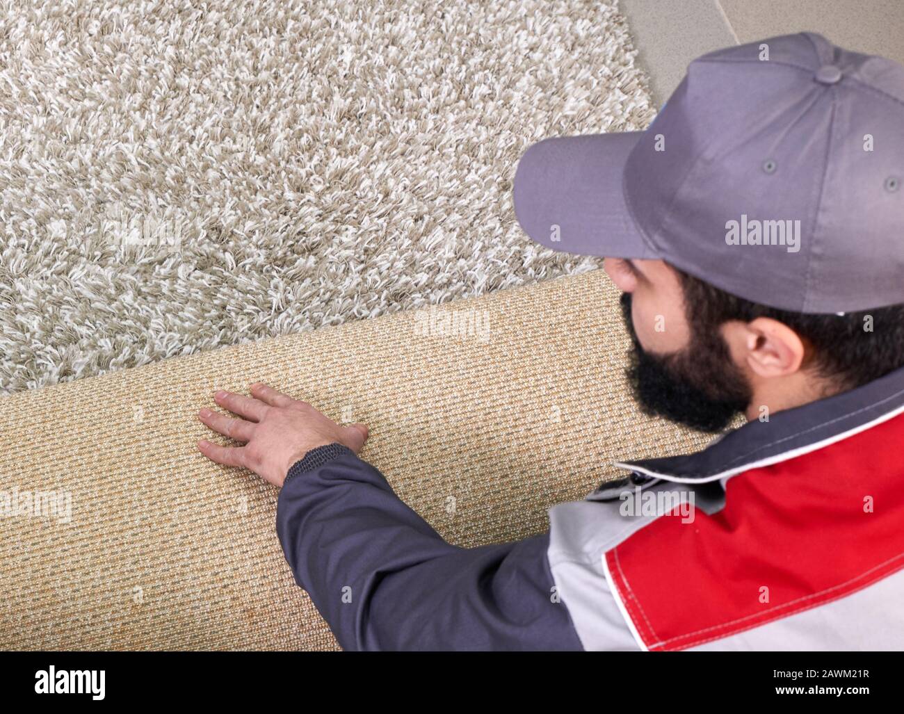 Male Worker Unrolling Carpet On Floor At Home Stock Photo - Alamy