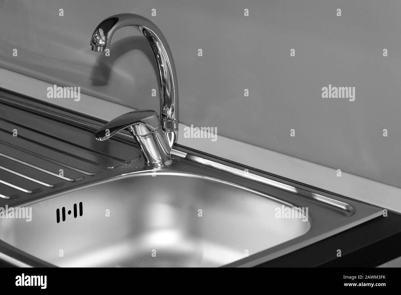 Small empty silver kitchen sink detail with faucet Stock Photo - Alamy