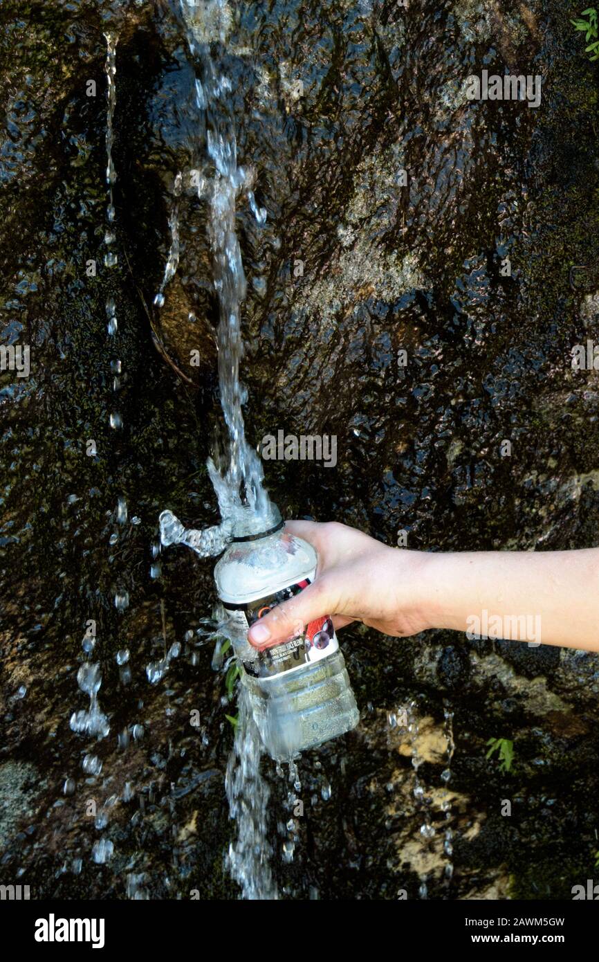 Getting water from a mountain stream Stock Photo - Alamy