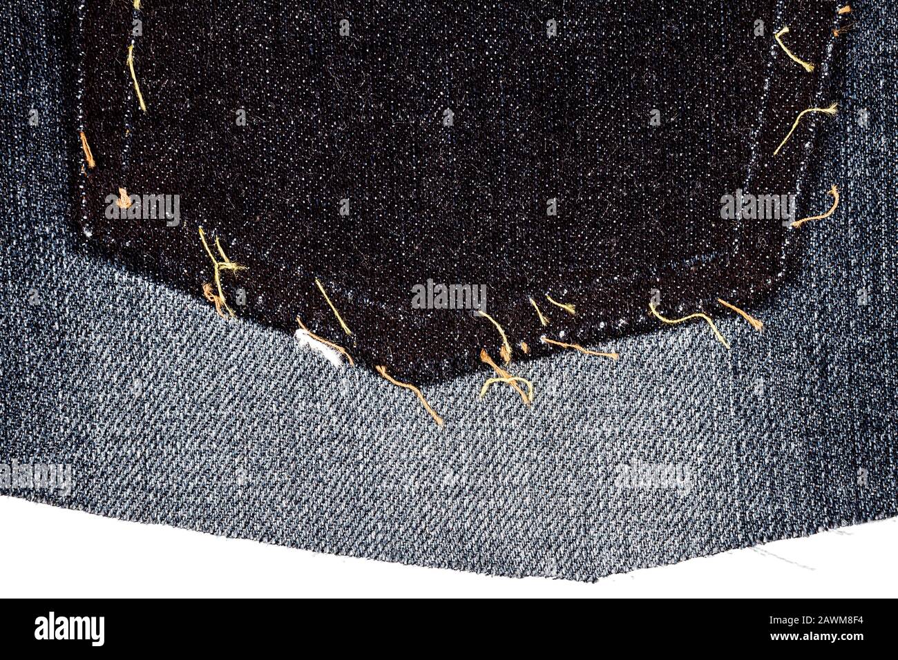 Piece of black jeans fabric with a ripped of back pocket isolated on ...