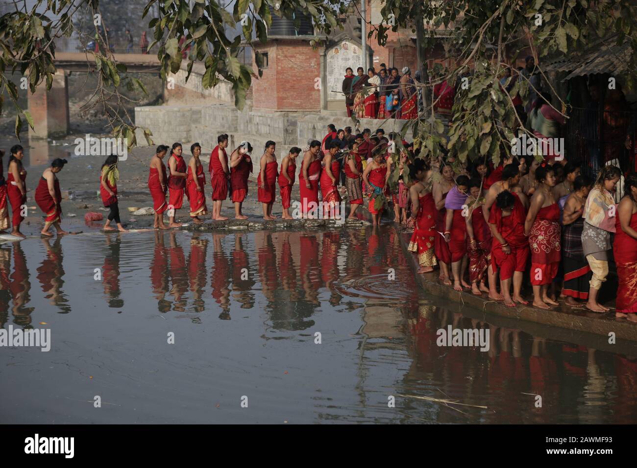 Nepalese devotees offer prayers before taking a holy bath at the bank ...