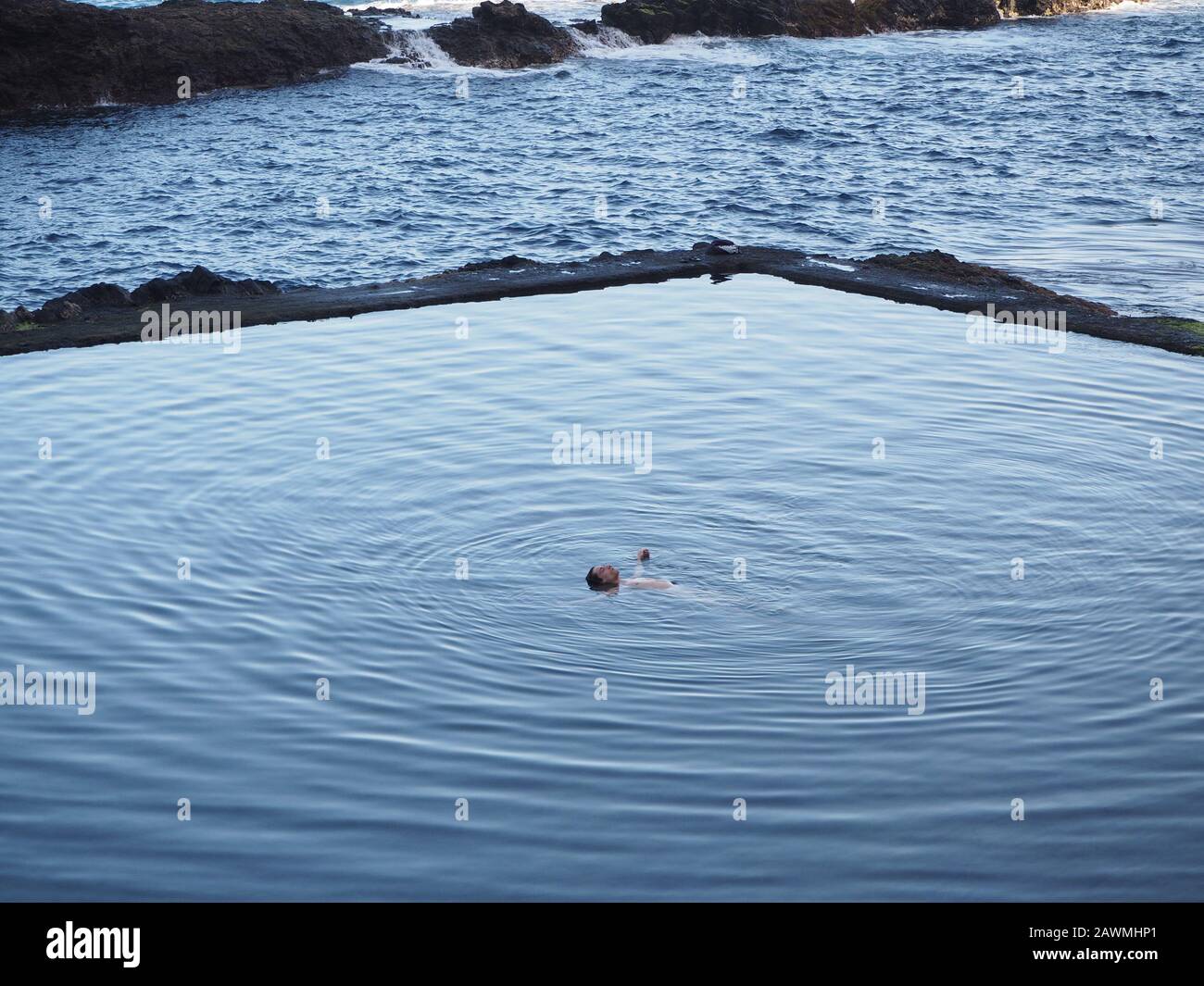 Person floating at a natural pool at the sea. Calm and relaxing Stock ...