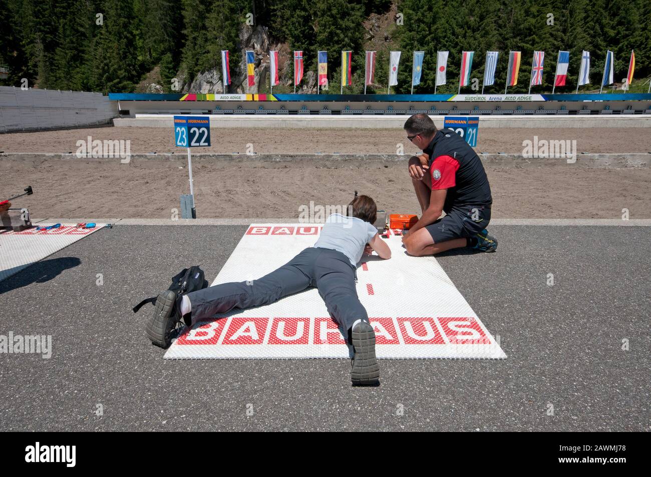 Instructor teaching visitor to shoot with biathlon rifle in Anterselva ...