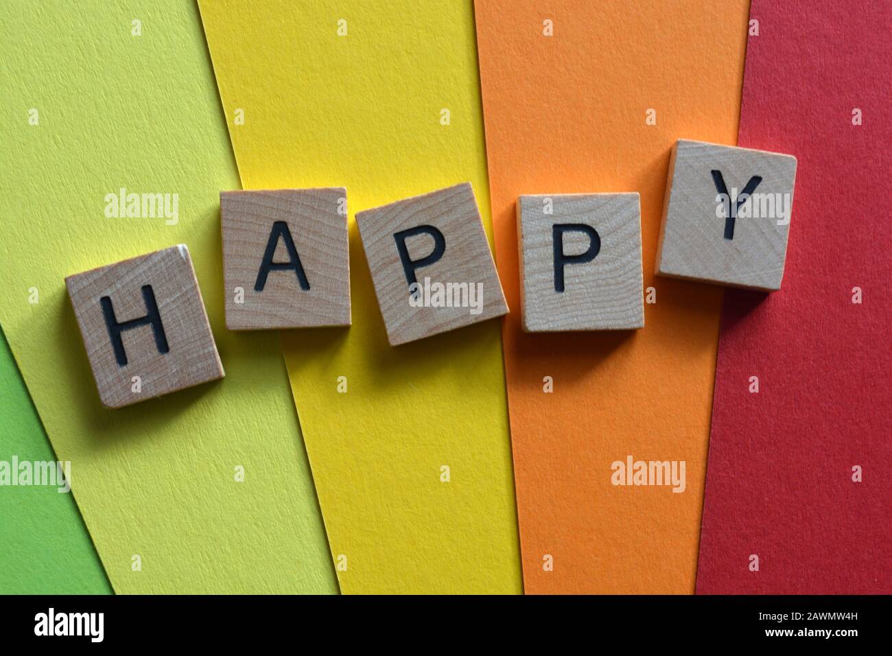 Happy, word in 3d wood alphabet letters a multicoloured background ...