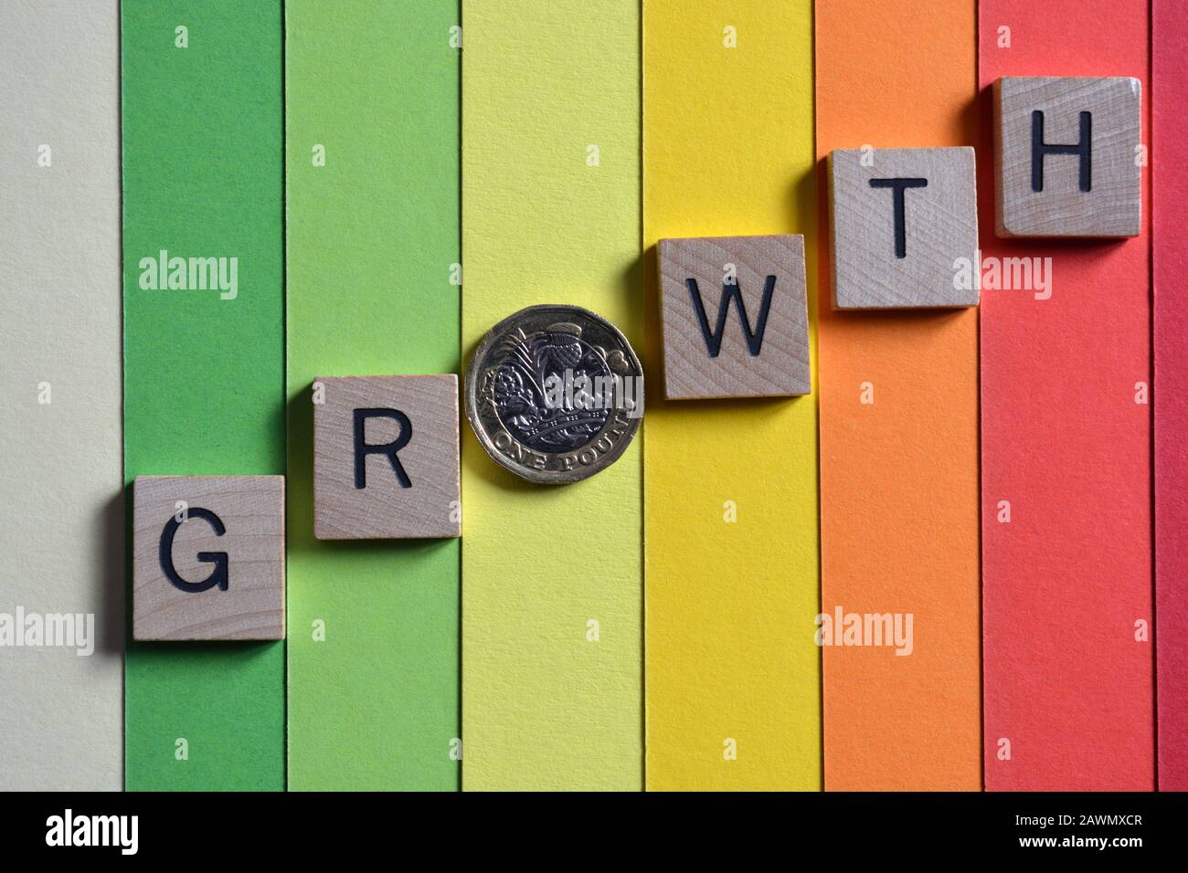 Growth, word in 3d wood alphabet letters on a multicoloured striped ...