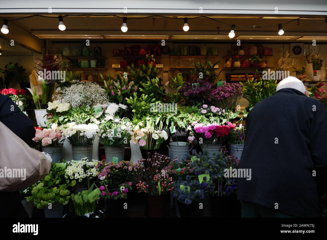 Customer choose colourful various bouquet of flowers in metal vases on ...