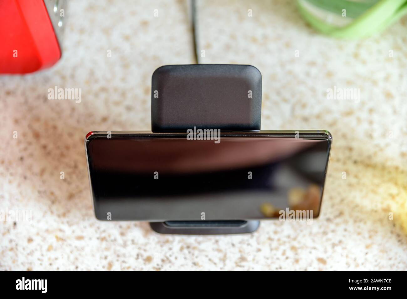 smartphone wireless charging on charging stand on kitchen tabletop ...