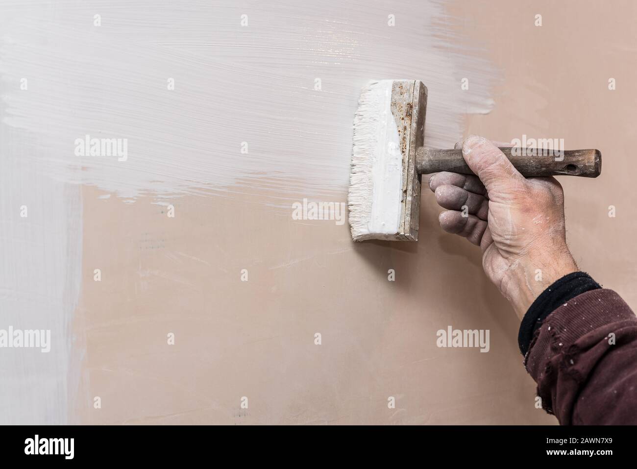 Master prime a putty wall before applying a decorative layer of plaster ...