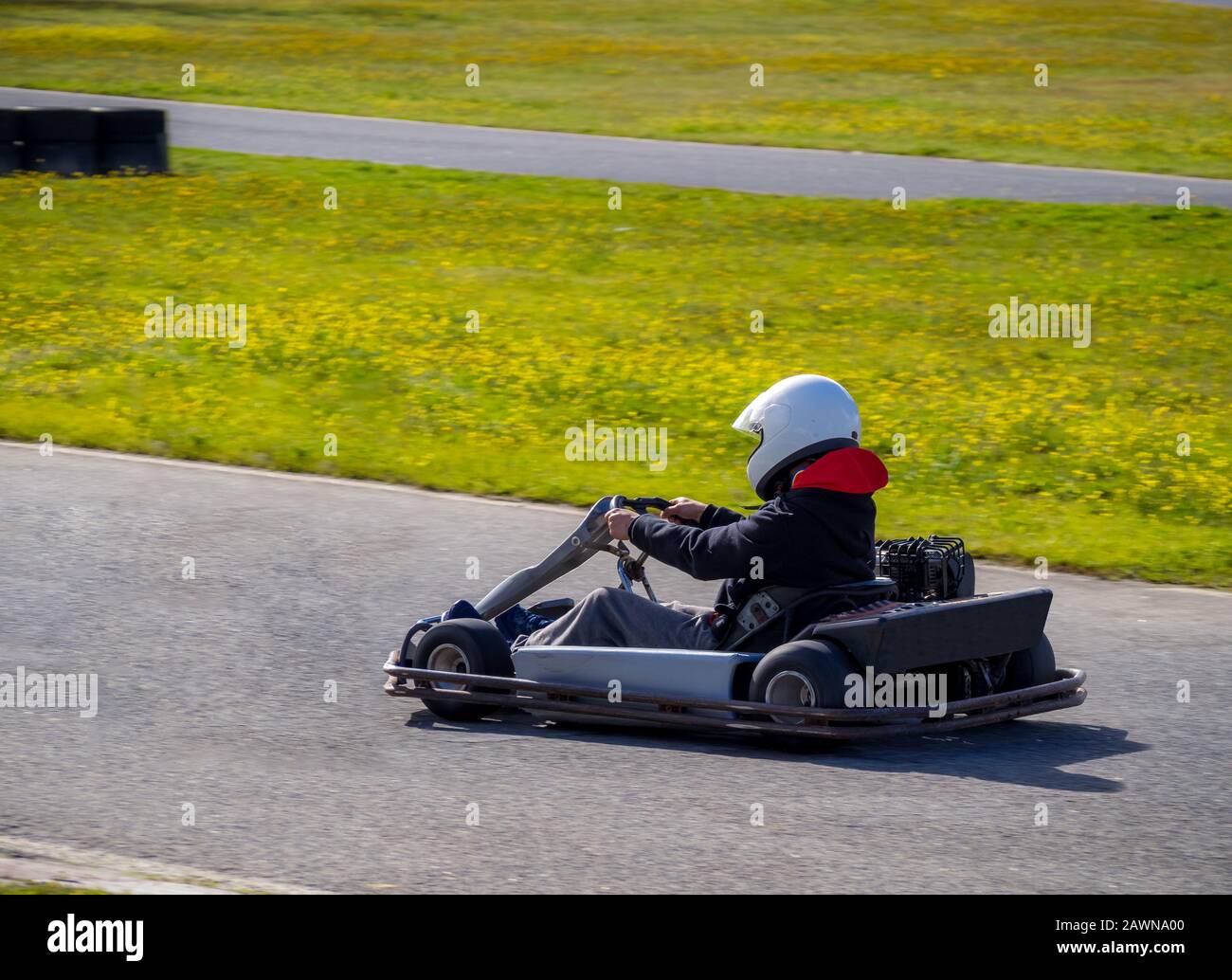 Go-cart racer with a white helmet on the circuit during daytime Stock ...