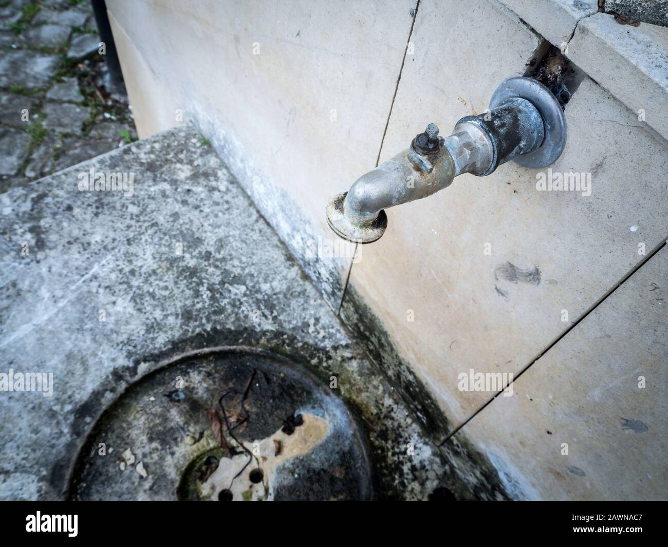 Weathered rusty faucet on a concrete wall during daytime Stock Photo ...