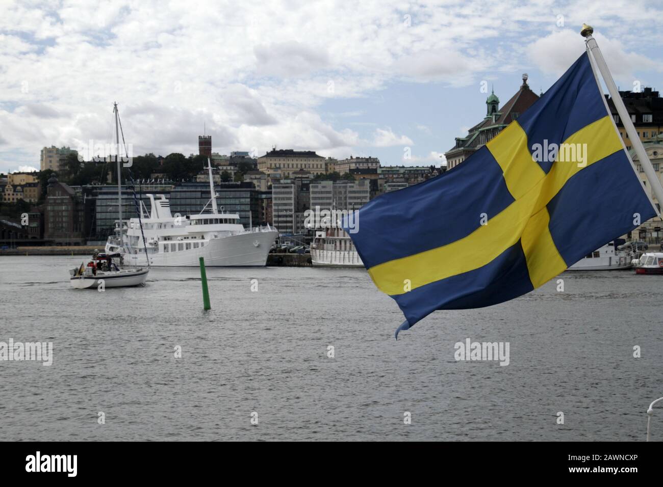 Wide angle shot of the flag of Sweden over the water behind the ...
