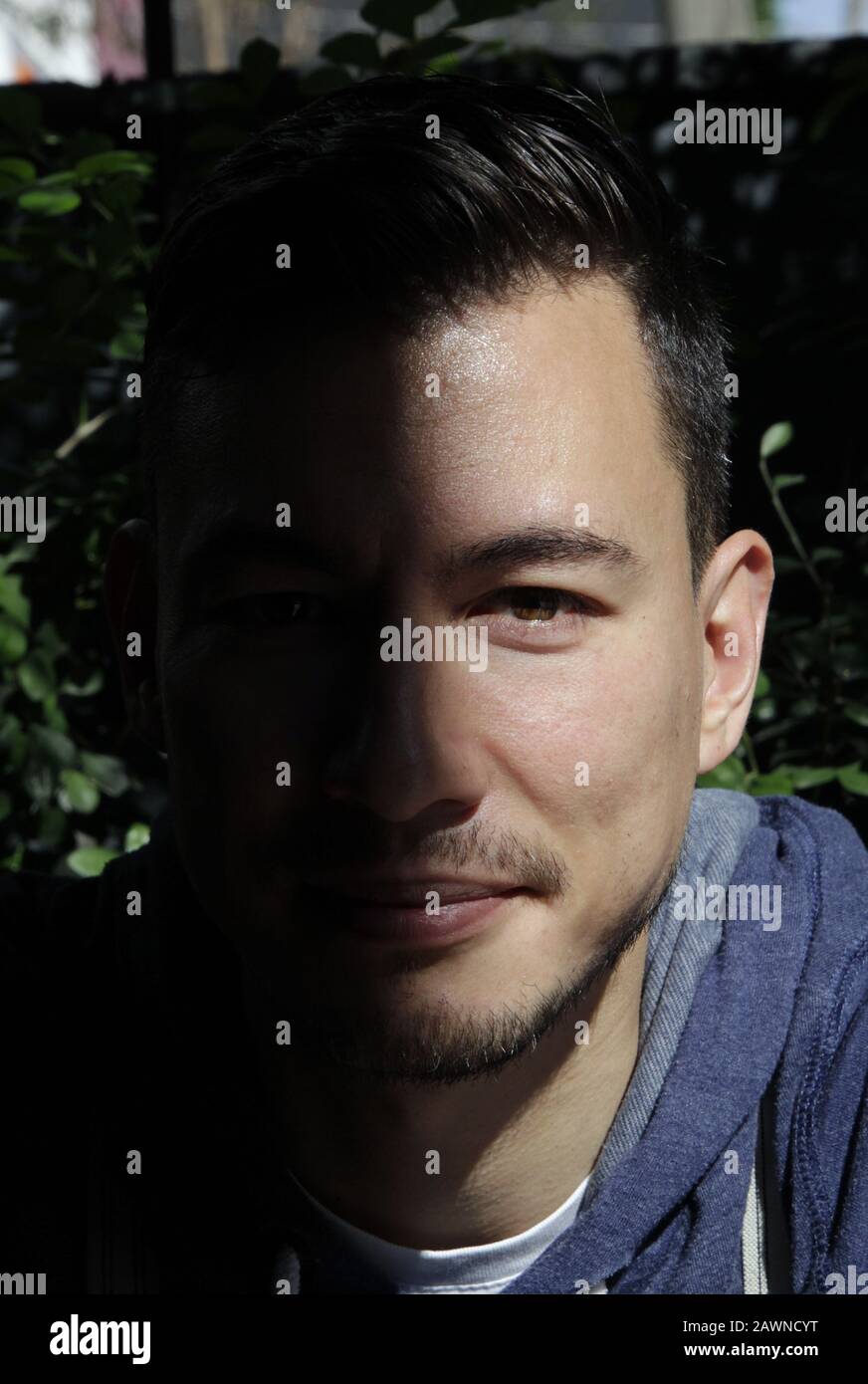 Vertical shot of a man having half of his face covered in shadow Stock ...