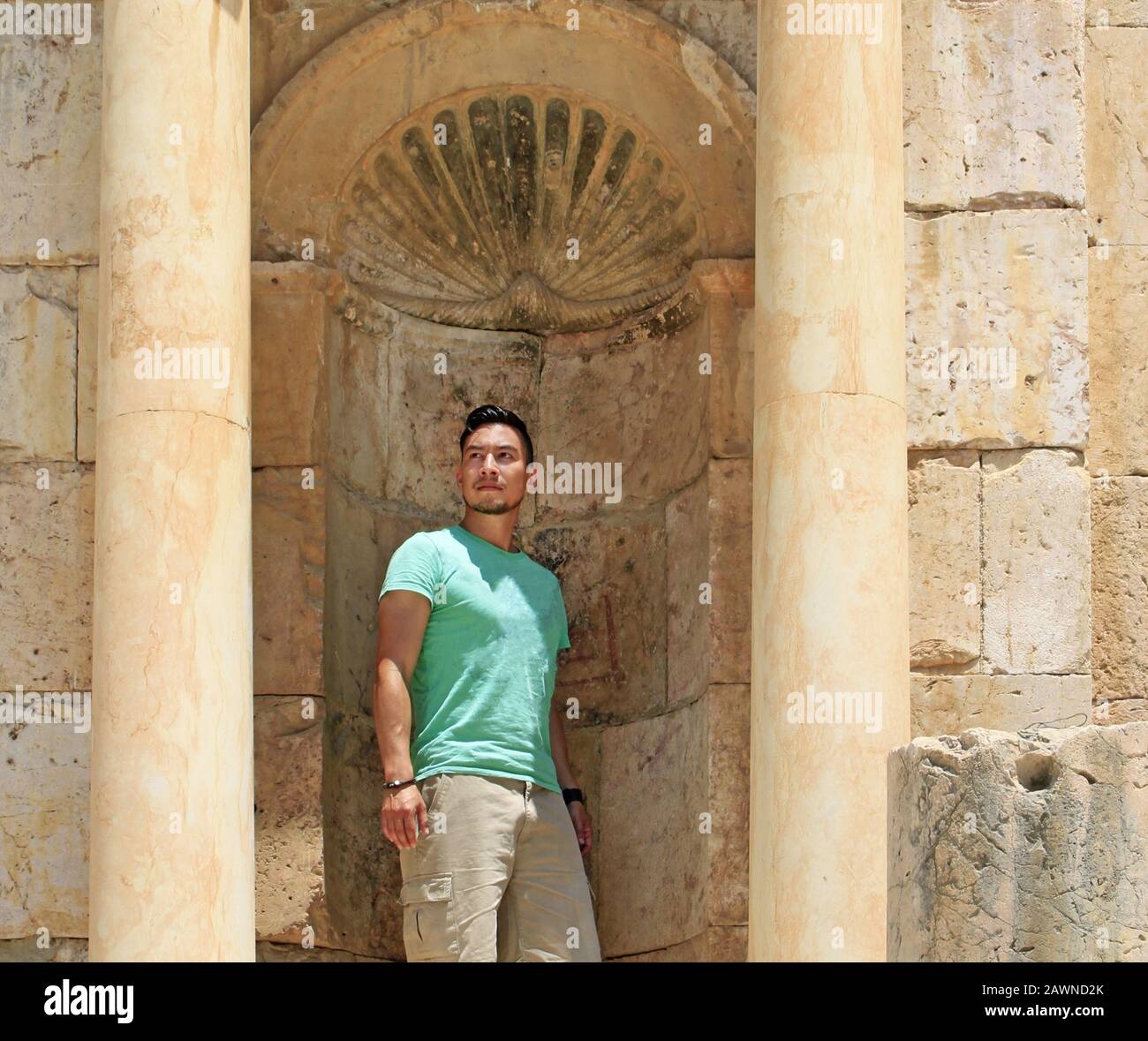 Wide angle shot of a man standing behind the columns and walls of an ...