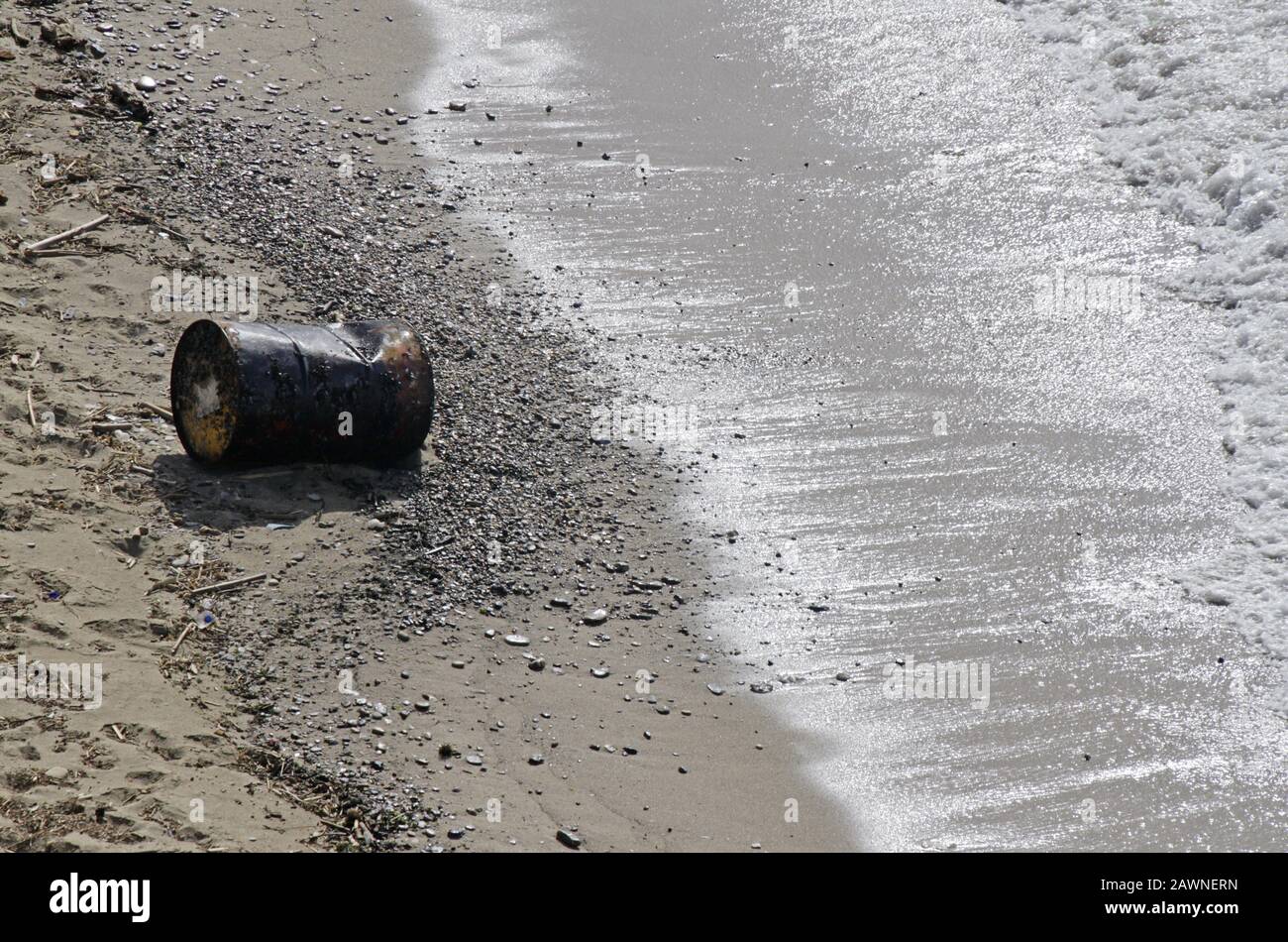 Large metal container tossed on the sand of the beach Stock Photo - Alamy