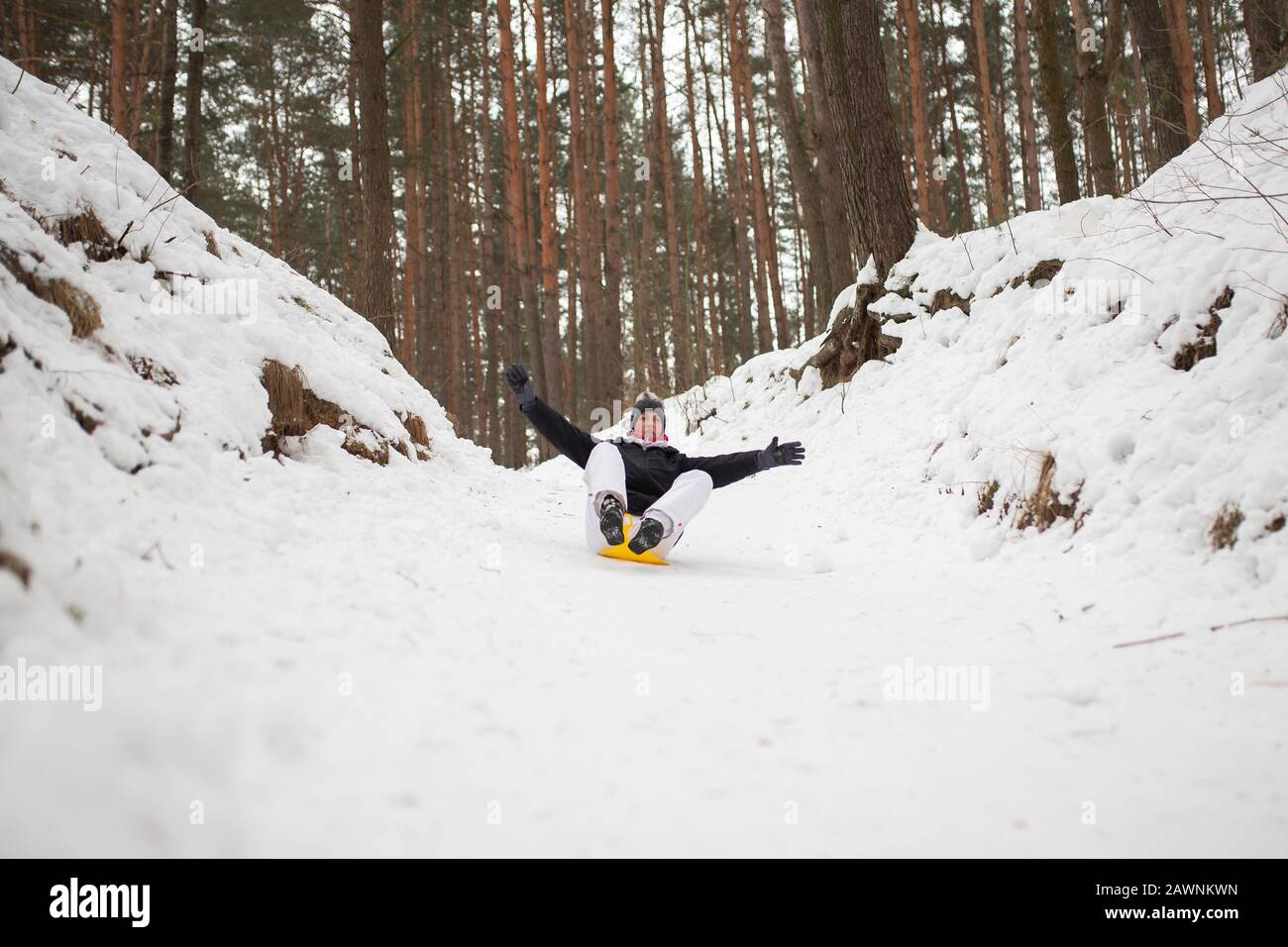 Adult woman rides on sled ice from a steep mountain. Winter fun Stock ...