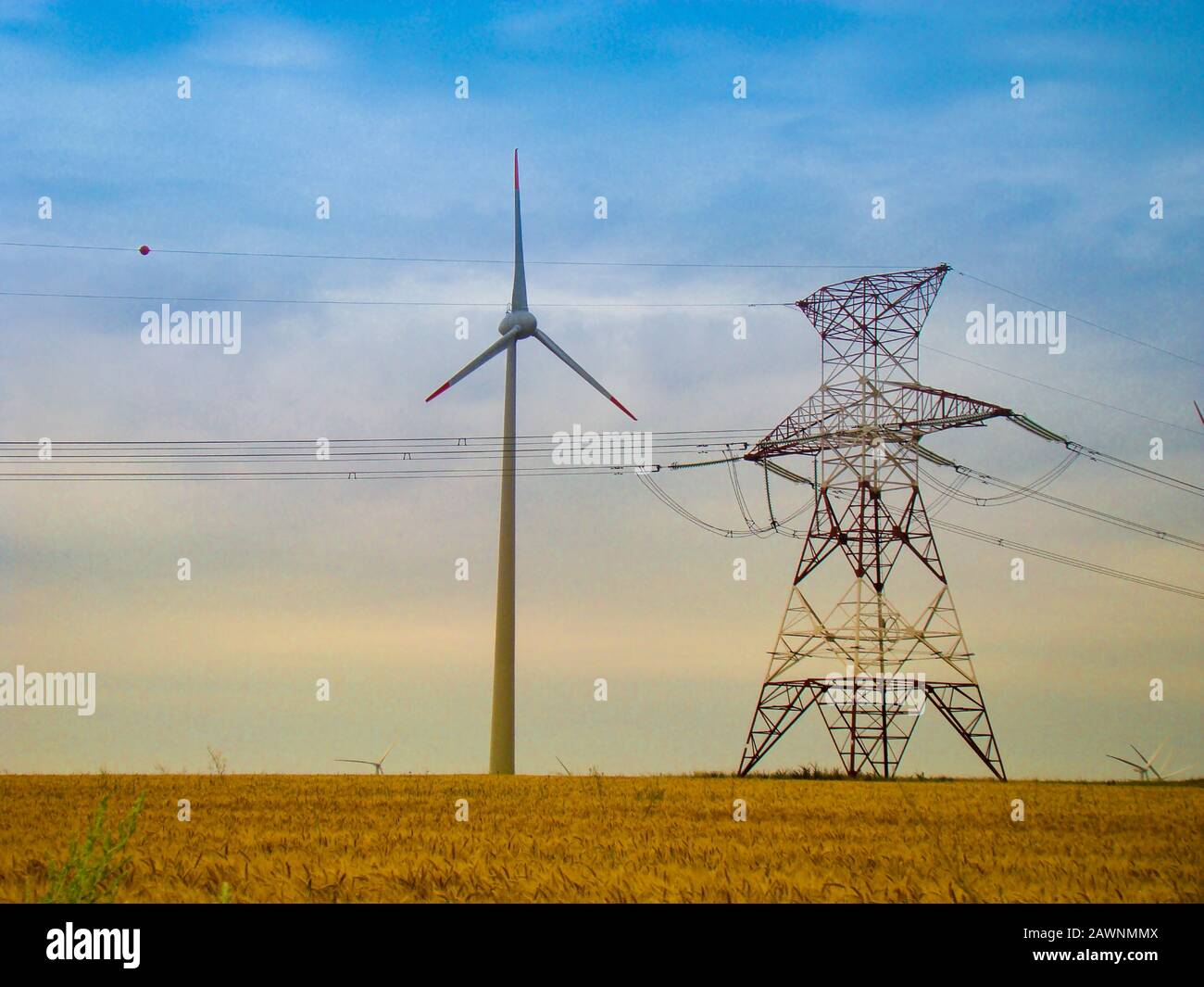Wind turbine and high voltage towerare on the yellow meadow. Wind farm ...